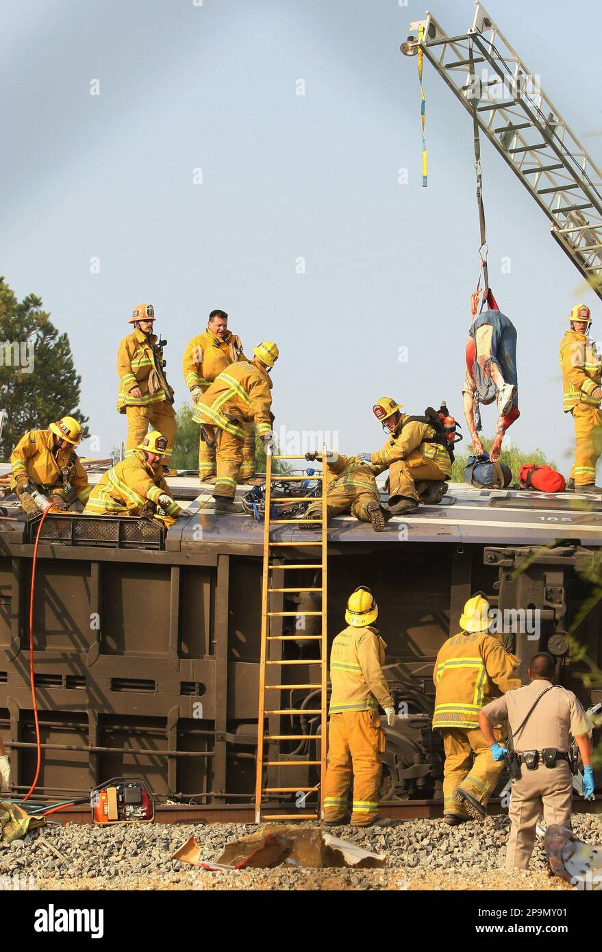 The body of a passenger is pulled out from an overturned train car at ...