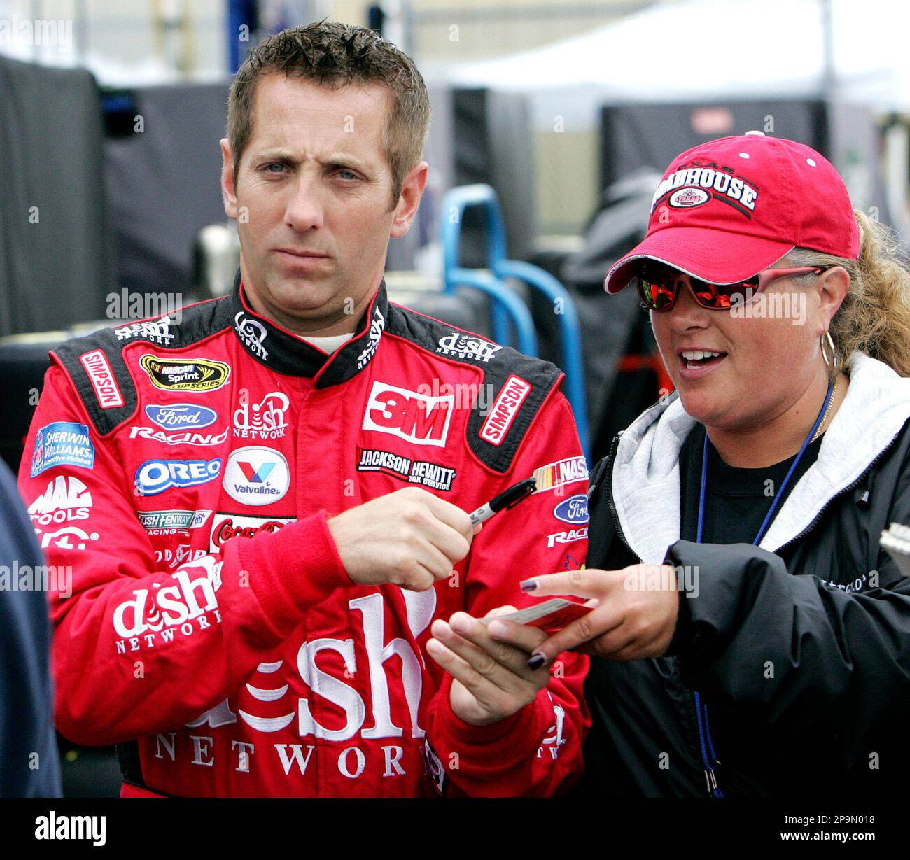 Driver Greg Biffle signs autographs as he makes his way to practice for ...