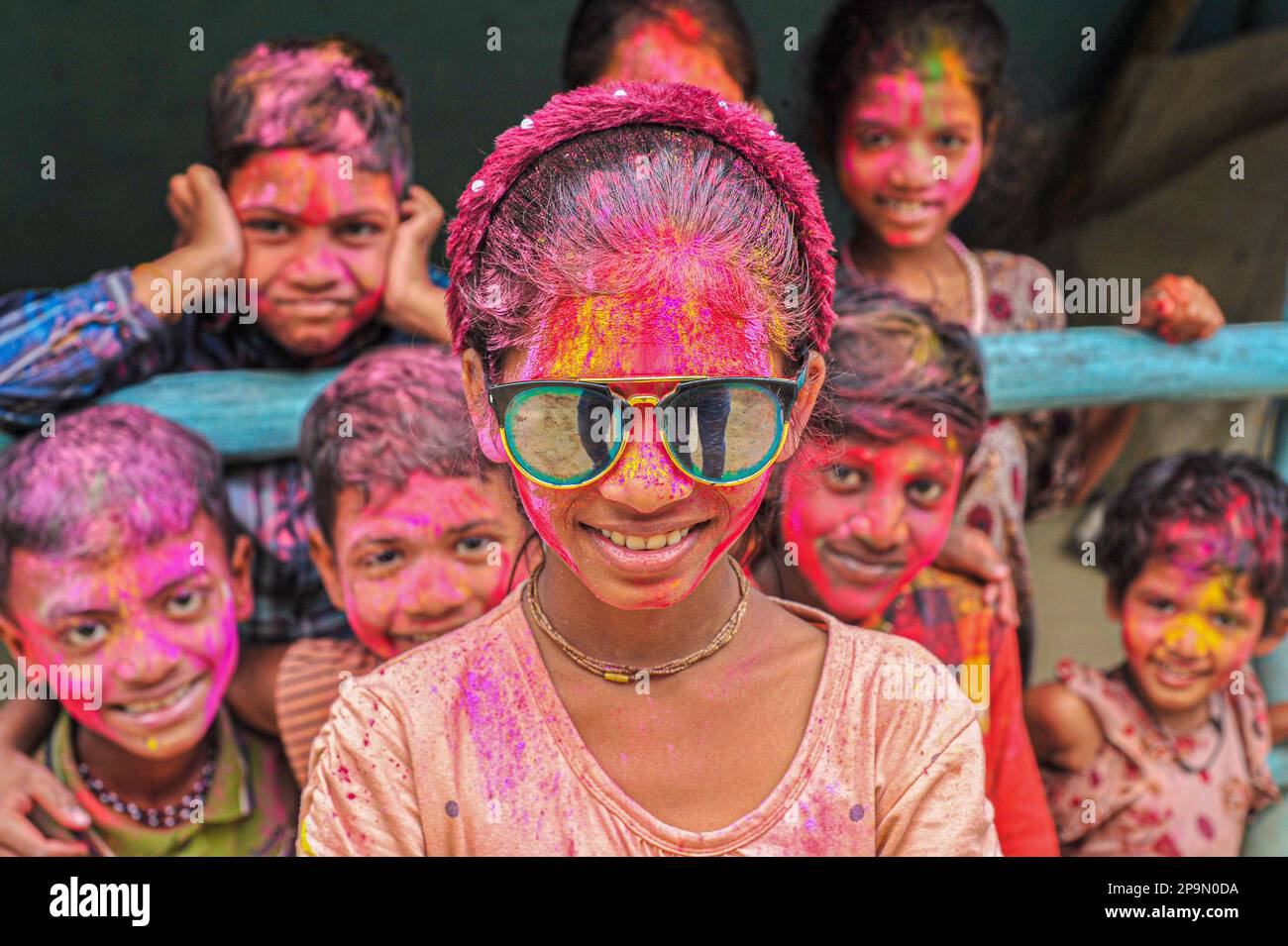 Children at a tea garden with painted faces in rainbow colours ...