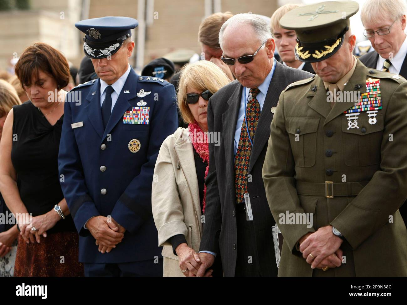 Military personnel and guests bow their heads during the dedication of ...