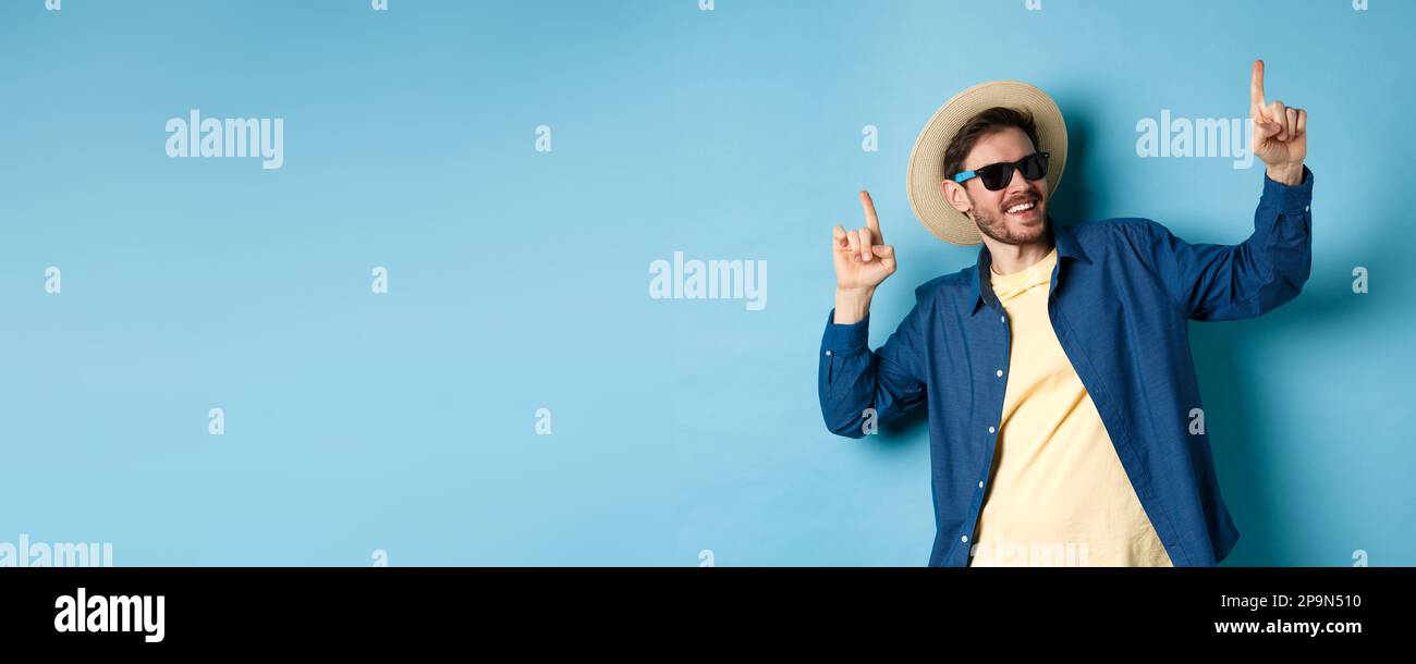 Funny tourist dancing on vacation, pointing fingers up, wearing summer ...