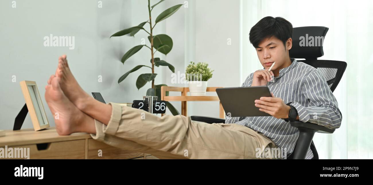 Casual man freelancer sitting on comfortable chair in modern home ...
