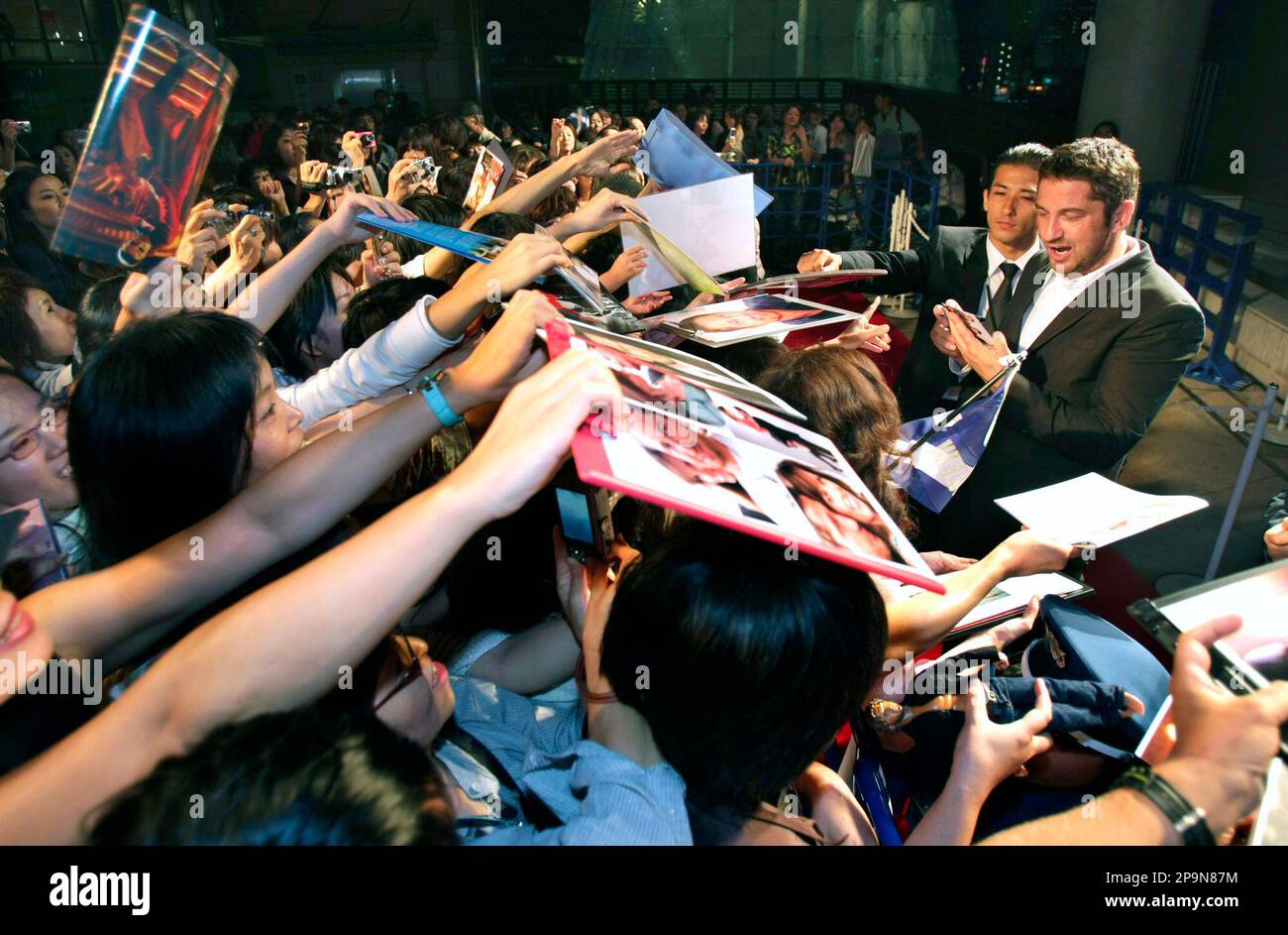 Actor Gerard Butler signs autographs as he arrives for the premiere of ...