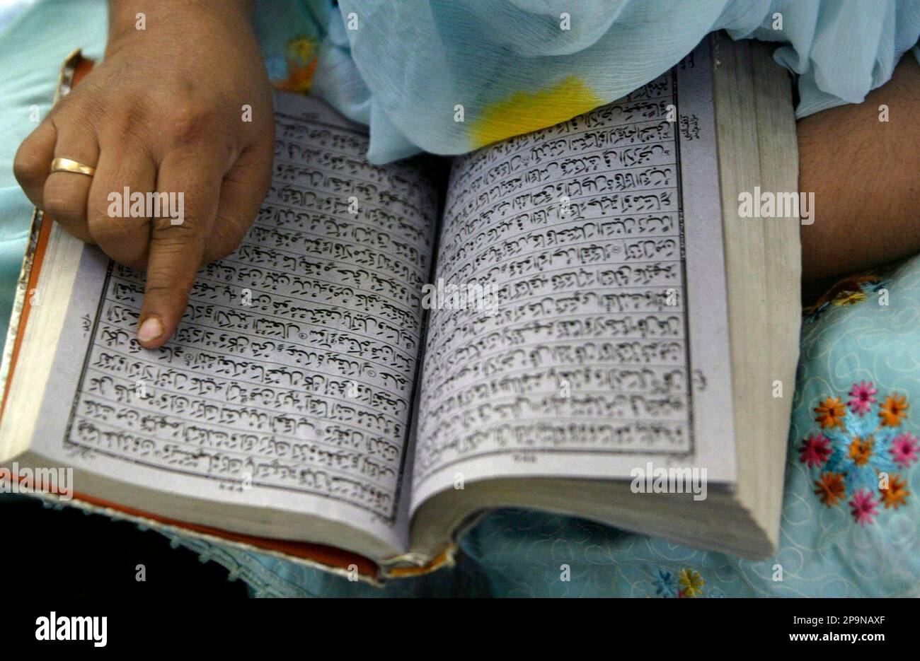 A Kashmiri Muslim woman recites Quran, or Muslim holy book, inside the ...