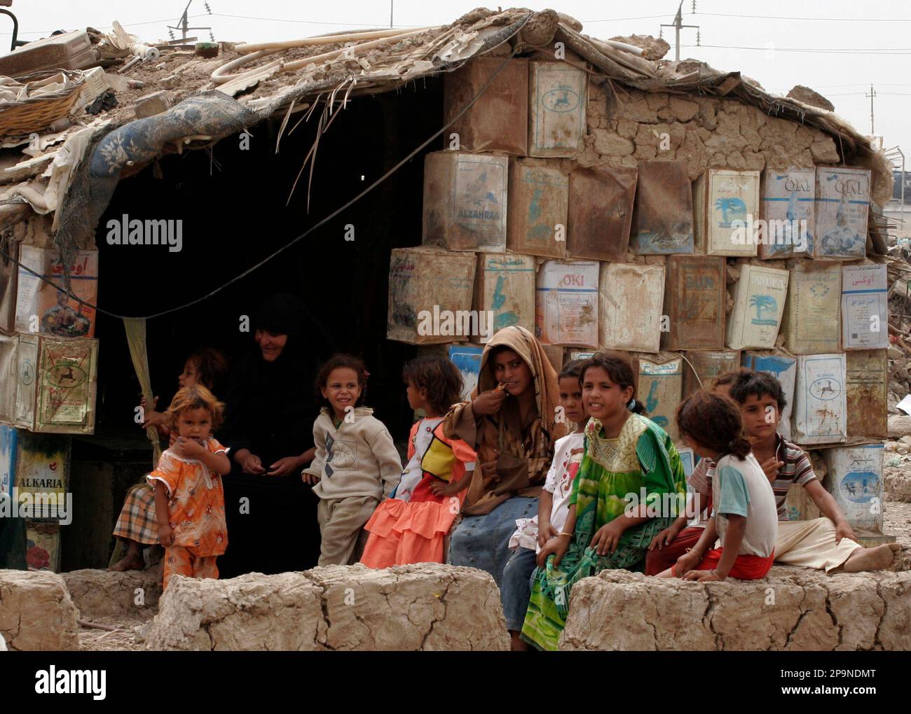 A family group is seen outside their home, which is constructed with ...