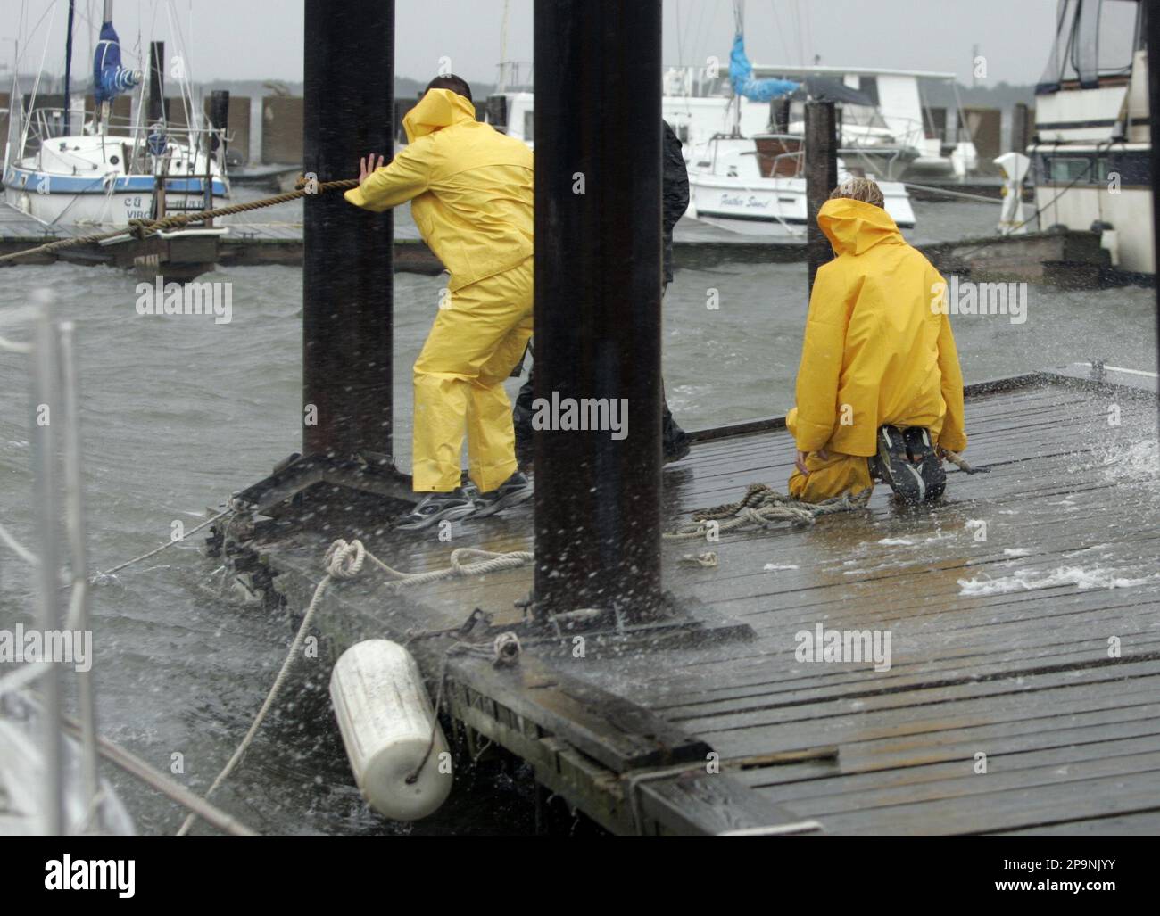 Dock hands secure a damaged float dock as rain and wind from Tropical ...