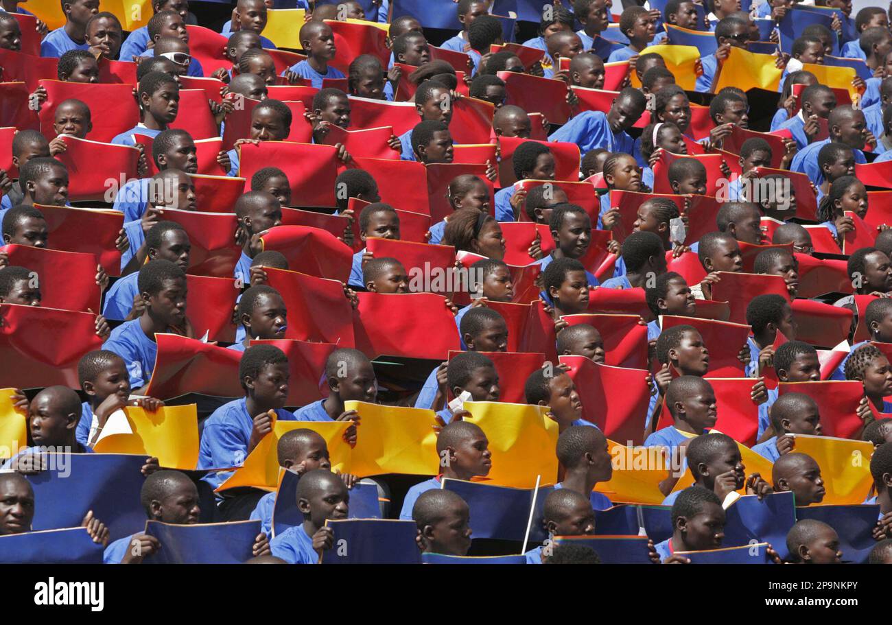 Children hold up placards in the colours of the Swaziland international ...
