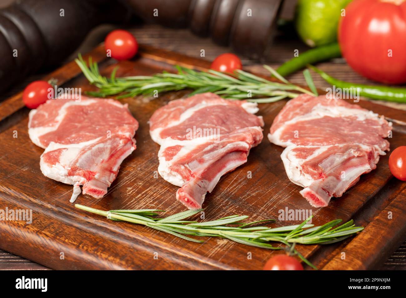Raw lamb chops. Fresh raw lamb chops with spices and herbs. Wood background. Close up Stock ...