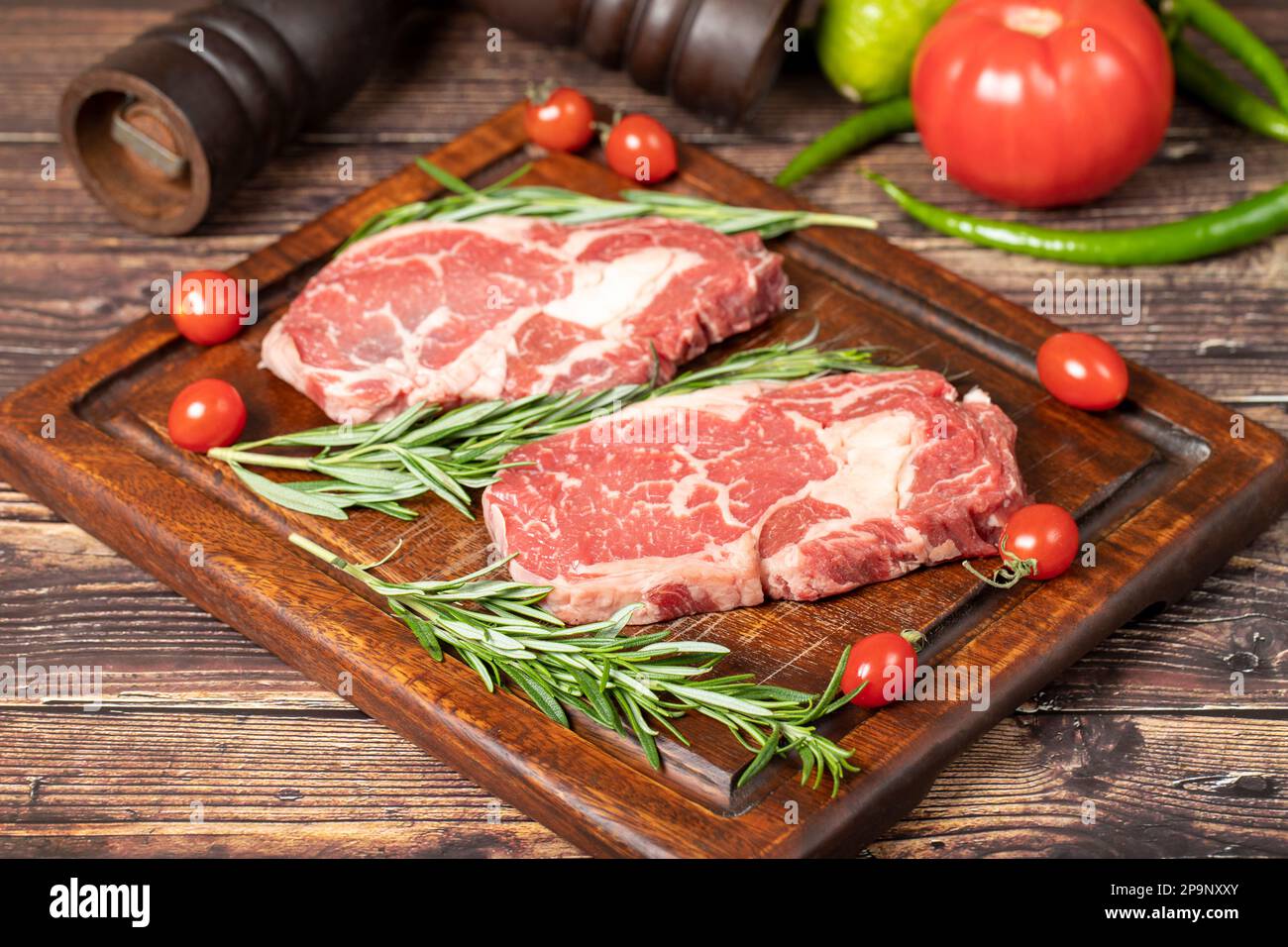 Beef ribeye. Two fresh raw ribeye steaks with spices and rosemary ...