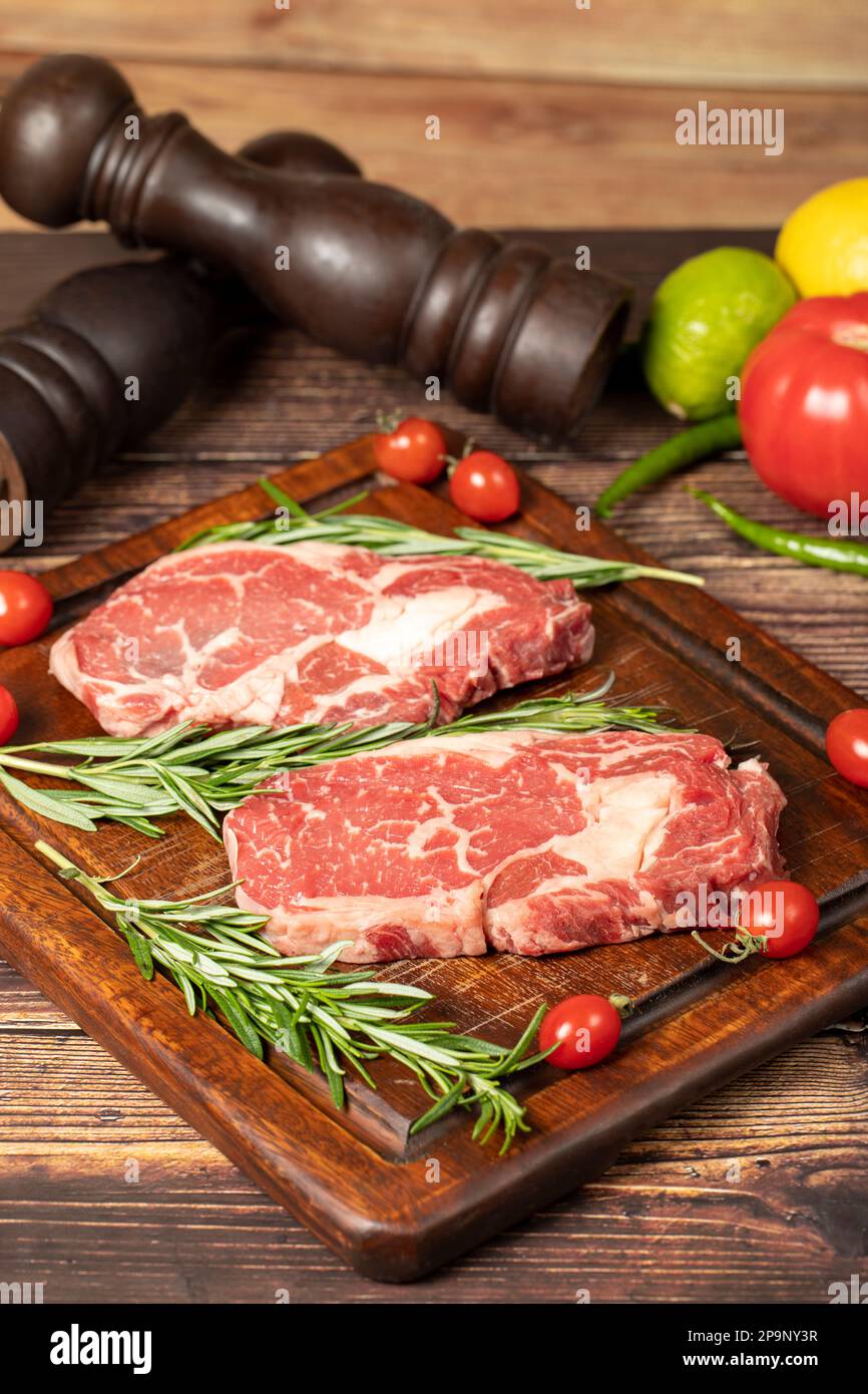Beef ribeye. Two fresh raw ribeye steaks with spices and rosemary ...