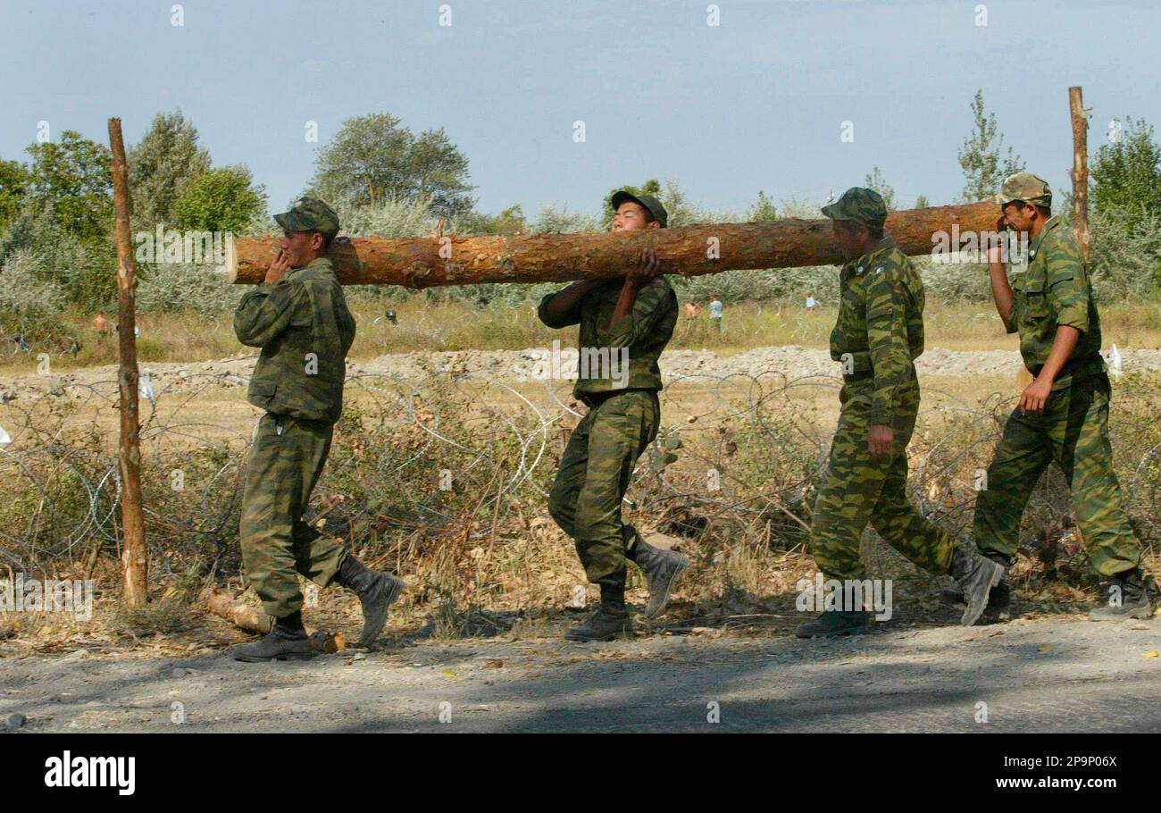 Russian soldiers carry a log at a Russian checkpoint at Karaleti, 7 km ...