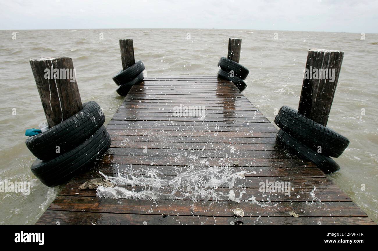 Water from the Gulf of Mexico hits the bottom of an empty fishing pier ...