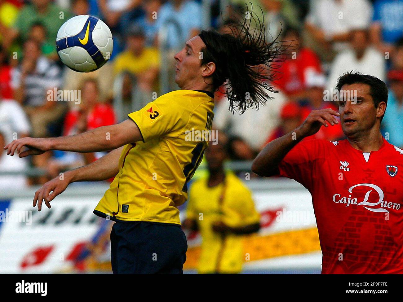 Barcelona's Leo Messi, left, controls the ball next to Numancia's Cesar ...
