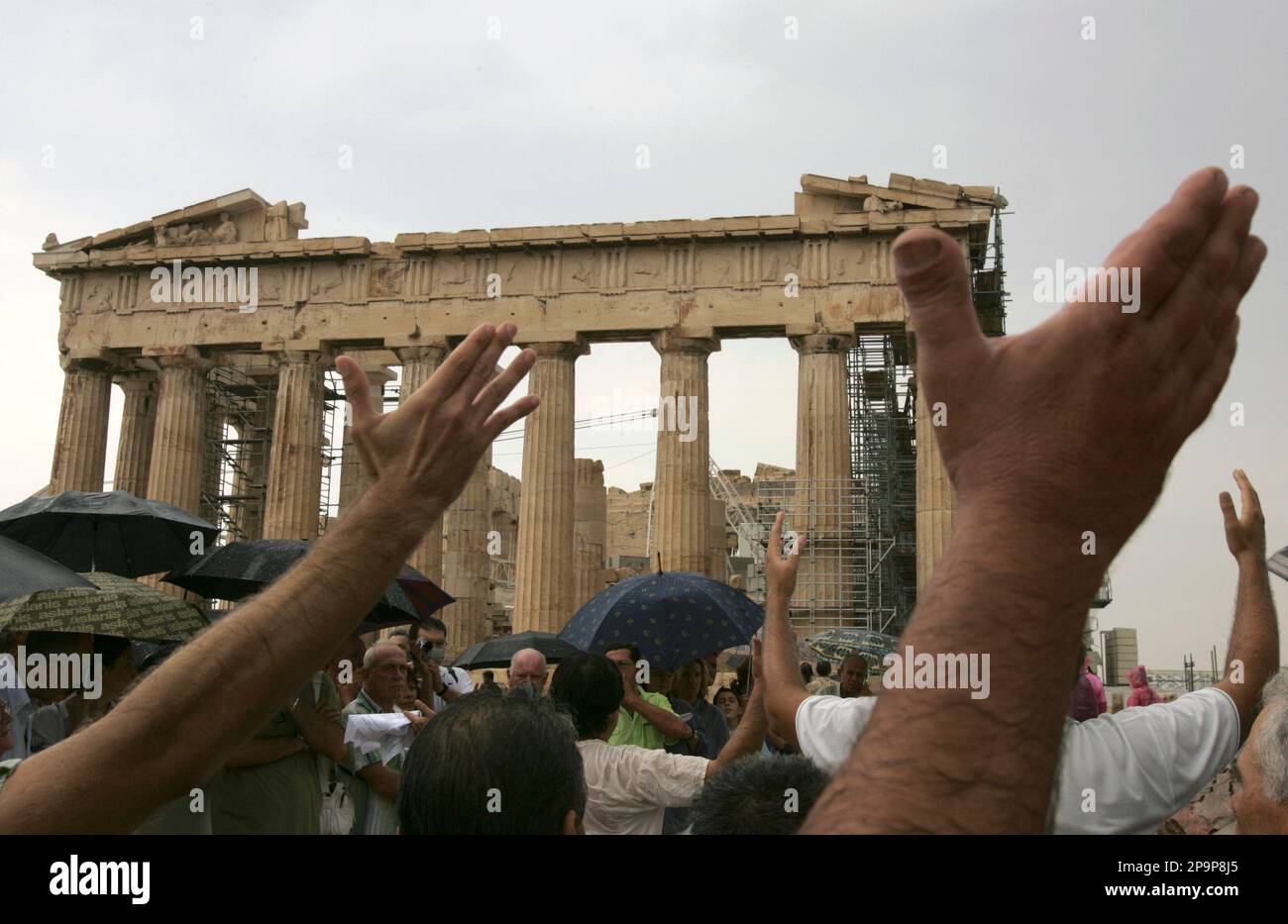 A small group of pagans raise their hands during a protest prayer among ...