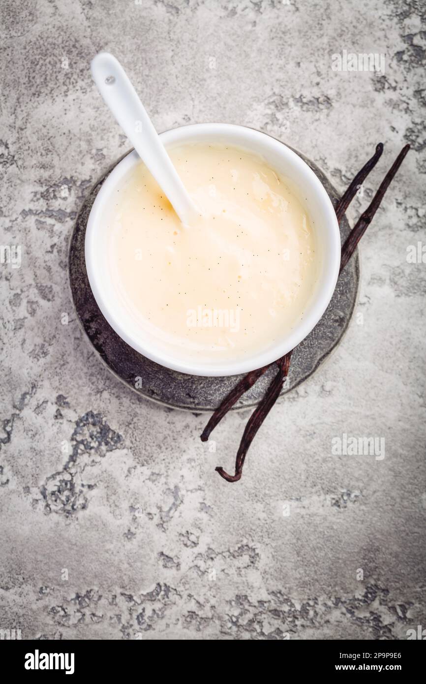 Homemade vanilla sauce in small bowl on grey background Stock Photo - Alamy