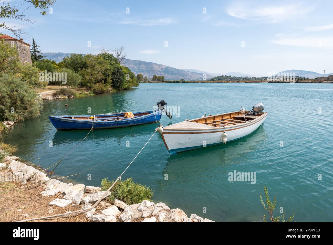 Wooden boats are moored on Butrint lake salt lagoon, view from Butrint ...