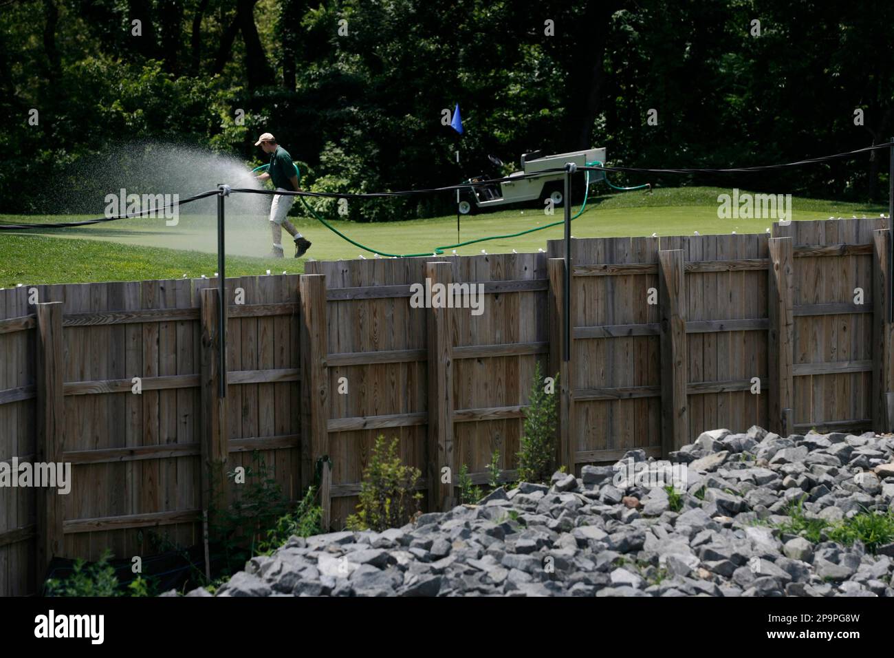 A worker at the golf course opposite the construction site for New York ...