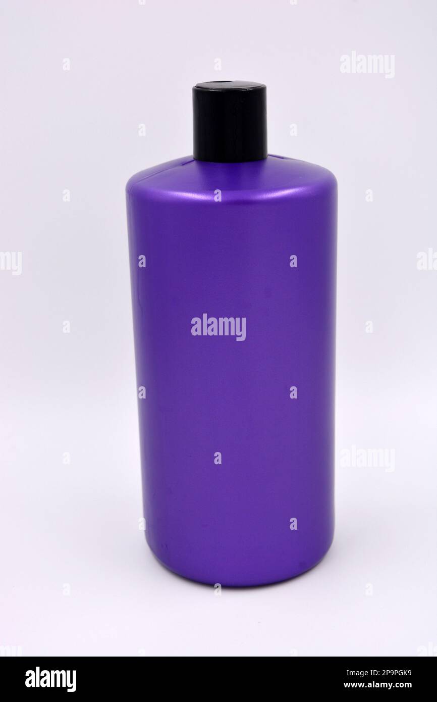 A large purple plastic round shampoo bottle with a black lid located on ...