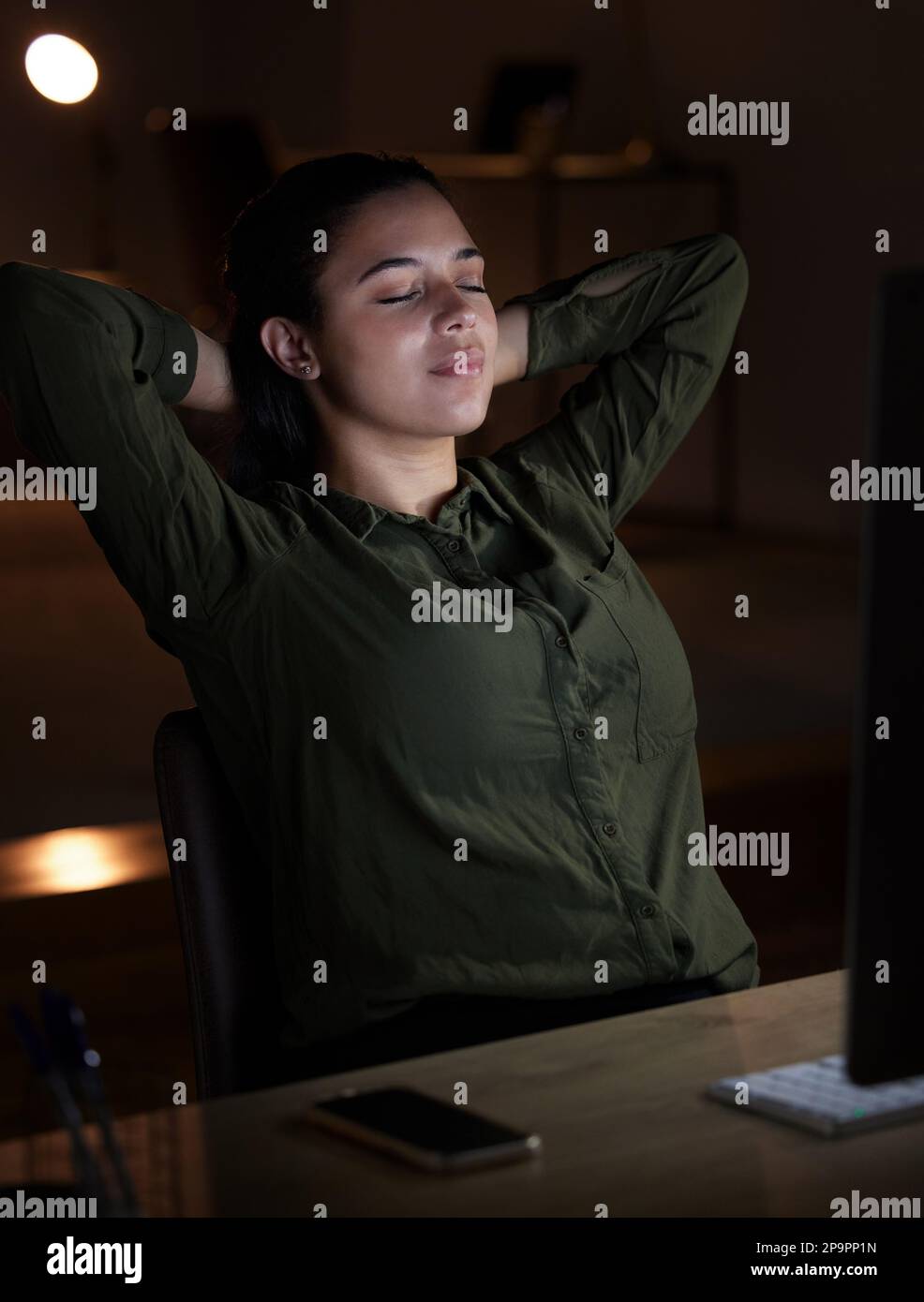 Night, relax and overtime with a business woman in her office, sitting ...