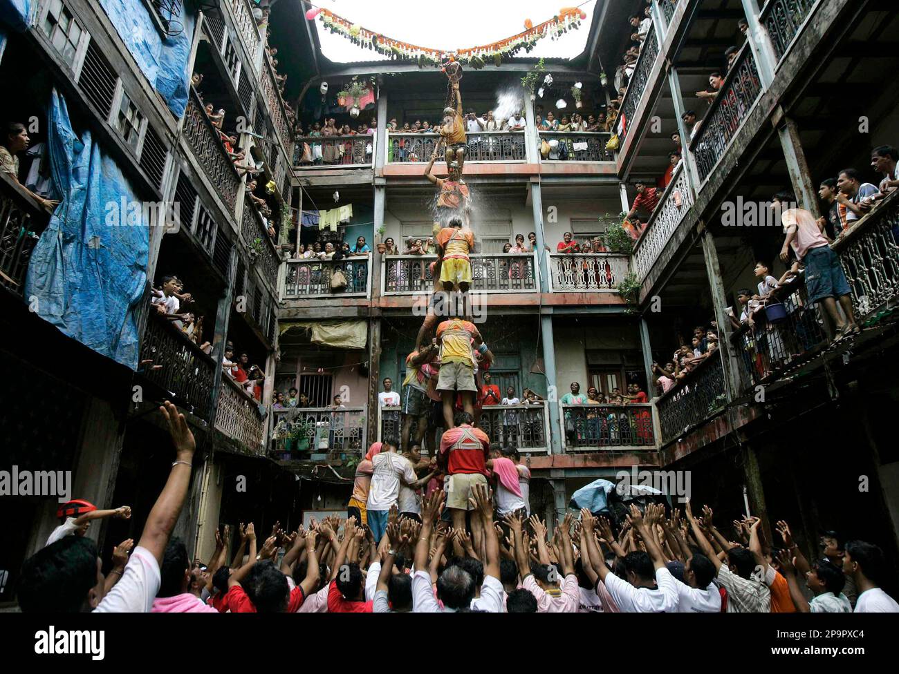 Hindu devotees, try to form a human pyramid to break an earthen pot ...