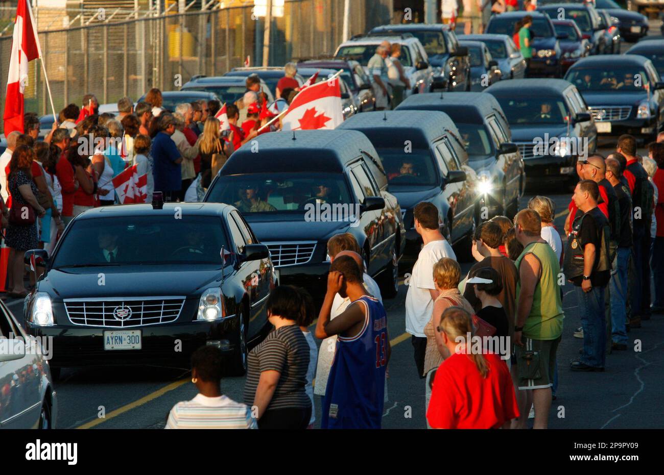 People watch a motorcade of hearses carry the bodies of fallen Canadian ...