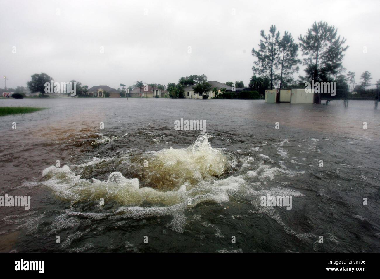 Water bubble out of a drain as rain from Tropical Storm Fay floods a ...