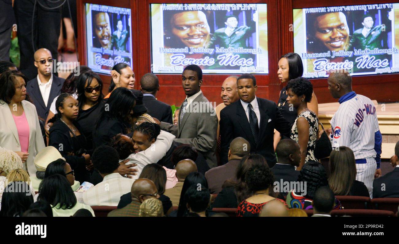 Family and firends embrace at a memorial service celebrating the life ...