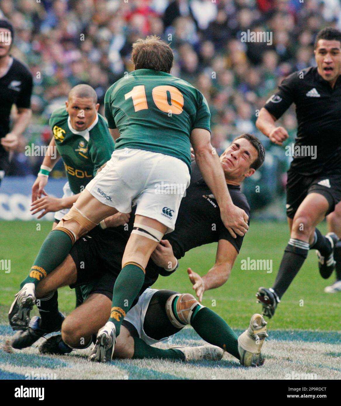 South Africa's Butch James, foreground left, tackles New Zealand's ...