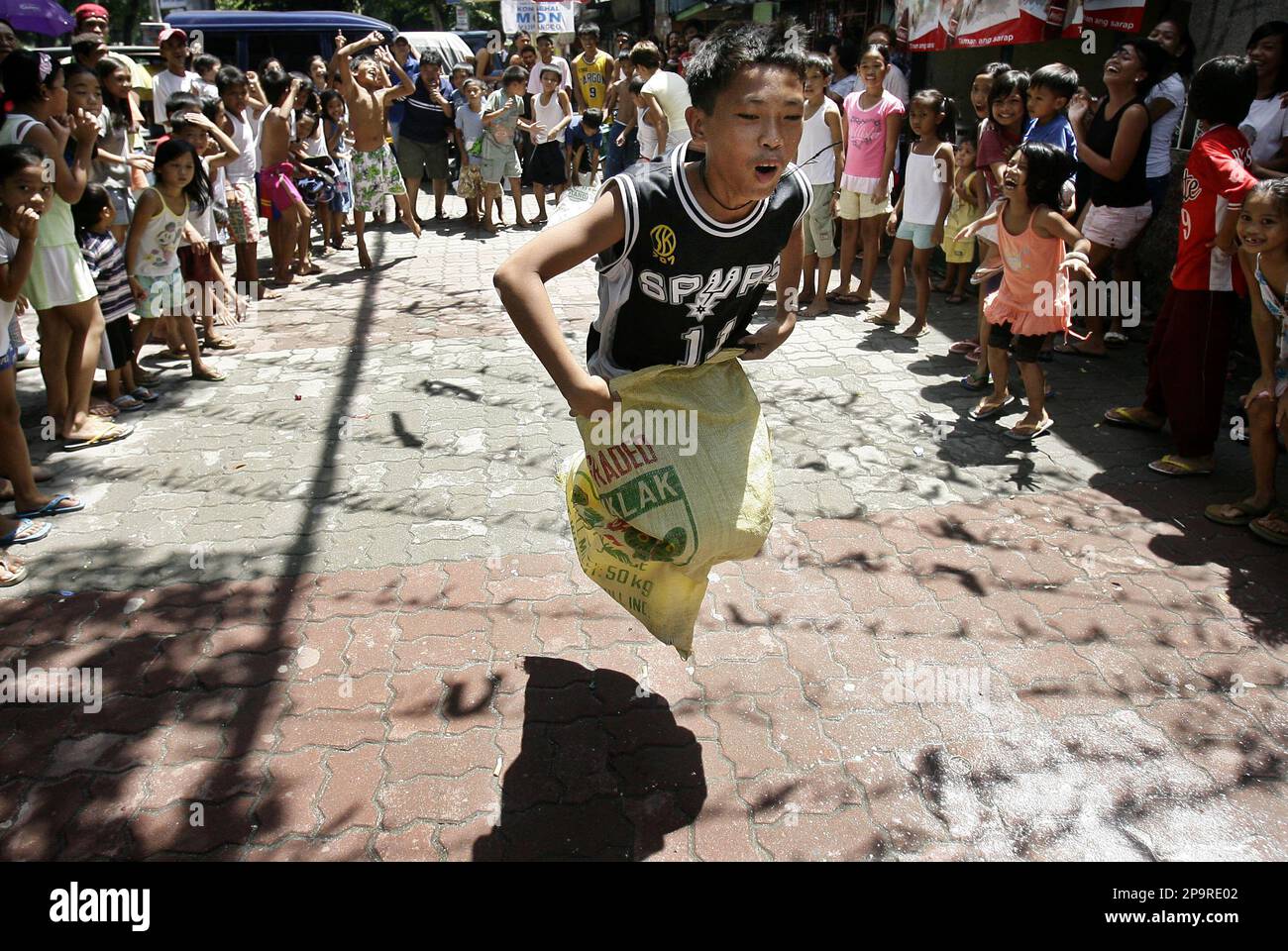 A Filipino child races during a sack race as they celebrate the feast ...