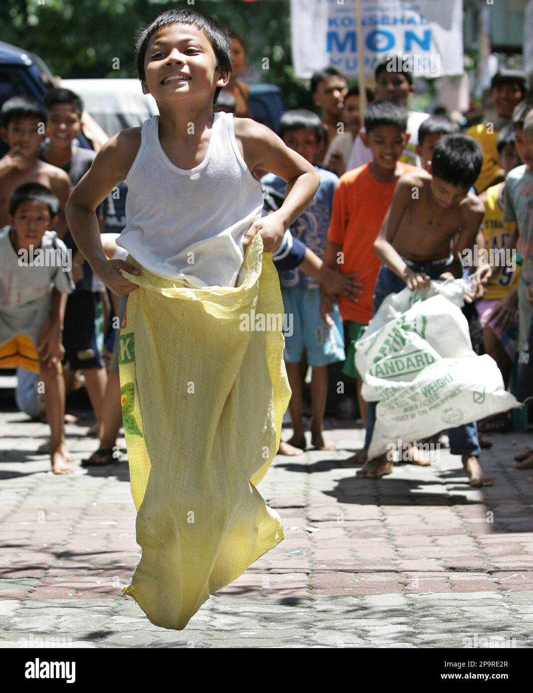 A Filipino boy races during a sack race as they celebrate the feast day ...