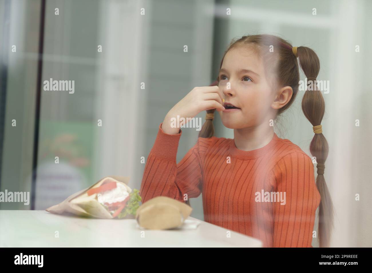 Cute white girl eating gyros in Greek fast food restaurant. Portrait of ...