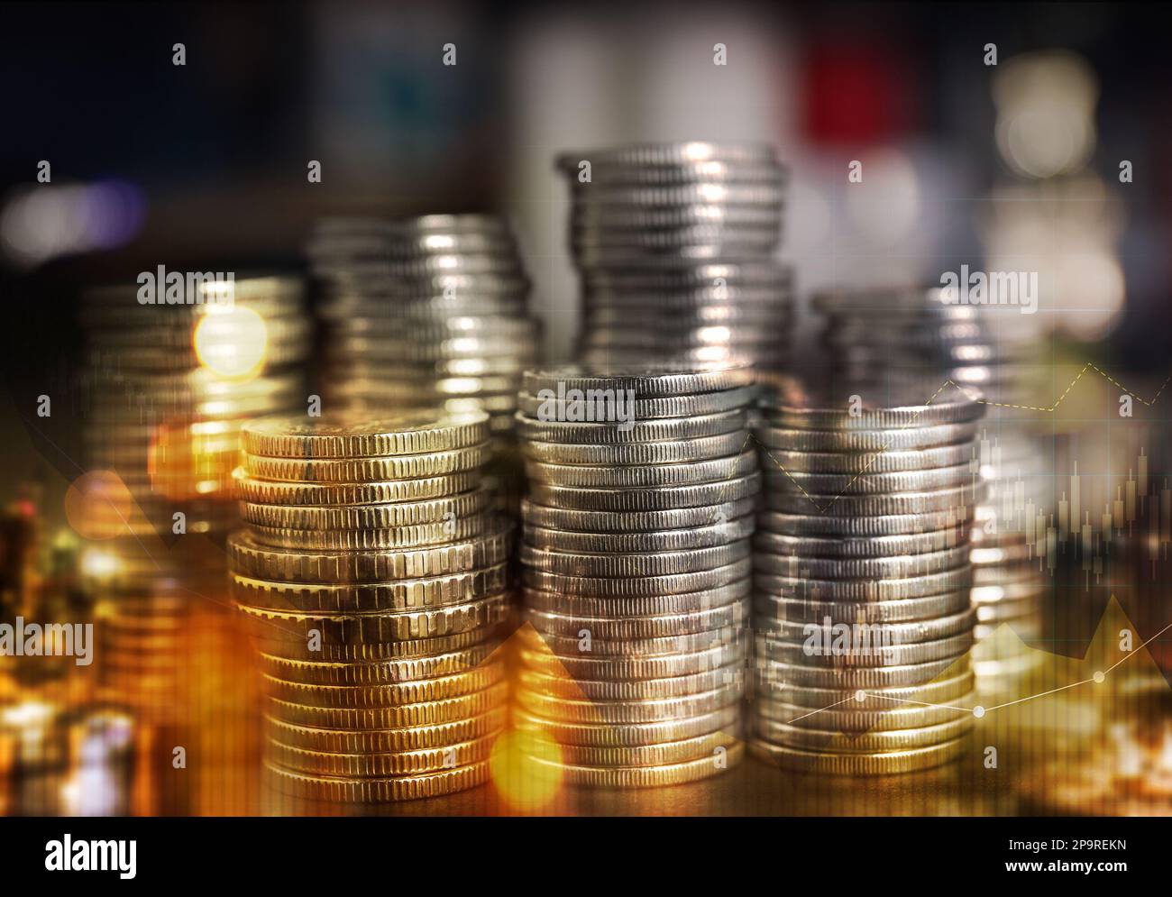 Stacked coins and charts on blurred background Stock Photo - Alamy