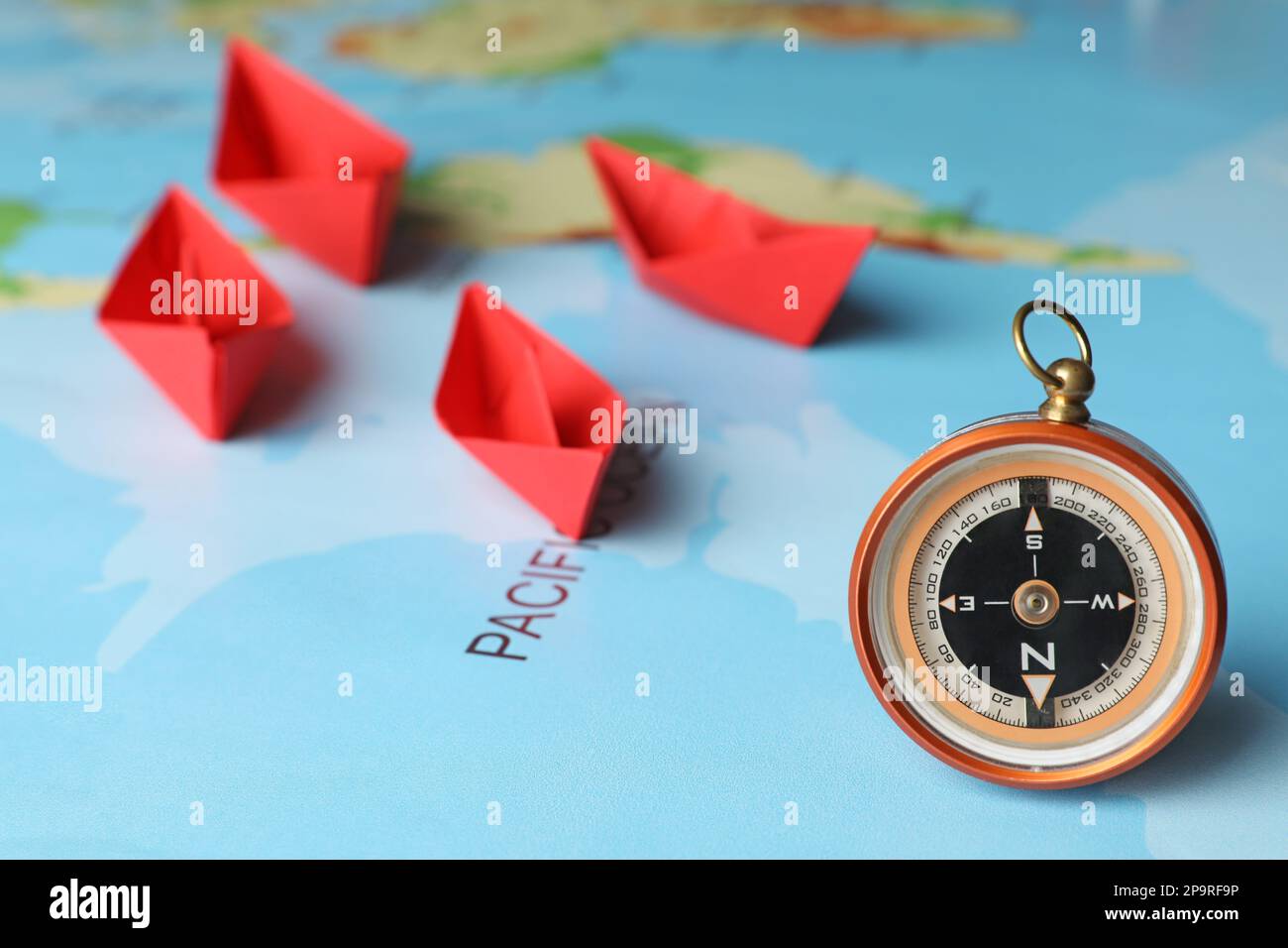 Bright paper boats and compass on world map Stock Photo - Alamy