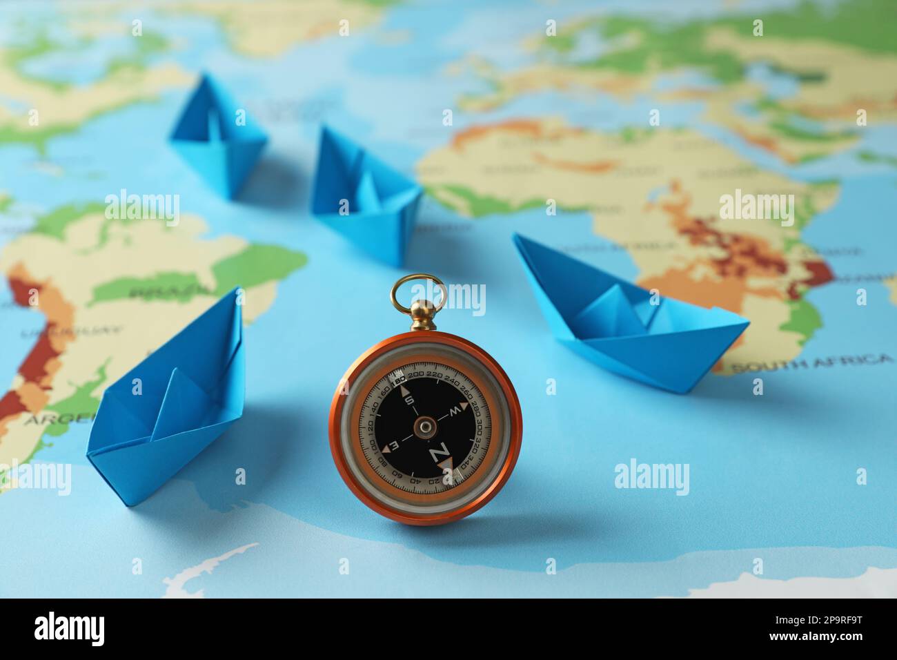 Bright paper boats and compass on world map Stock Photo - Alamy