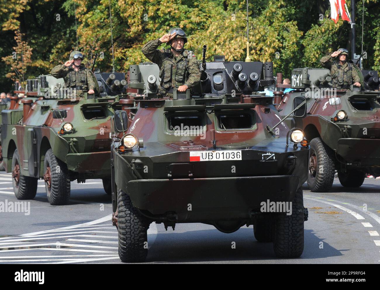 Armoured military vehicles roll down a downtown avenue during a ...