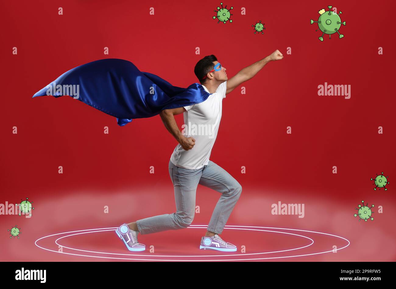 Man wearing superhero costume fighting against viruses on red ...