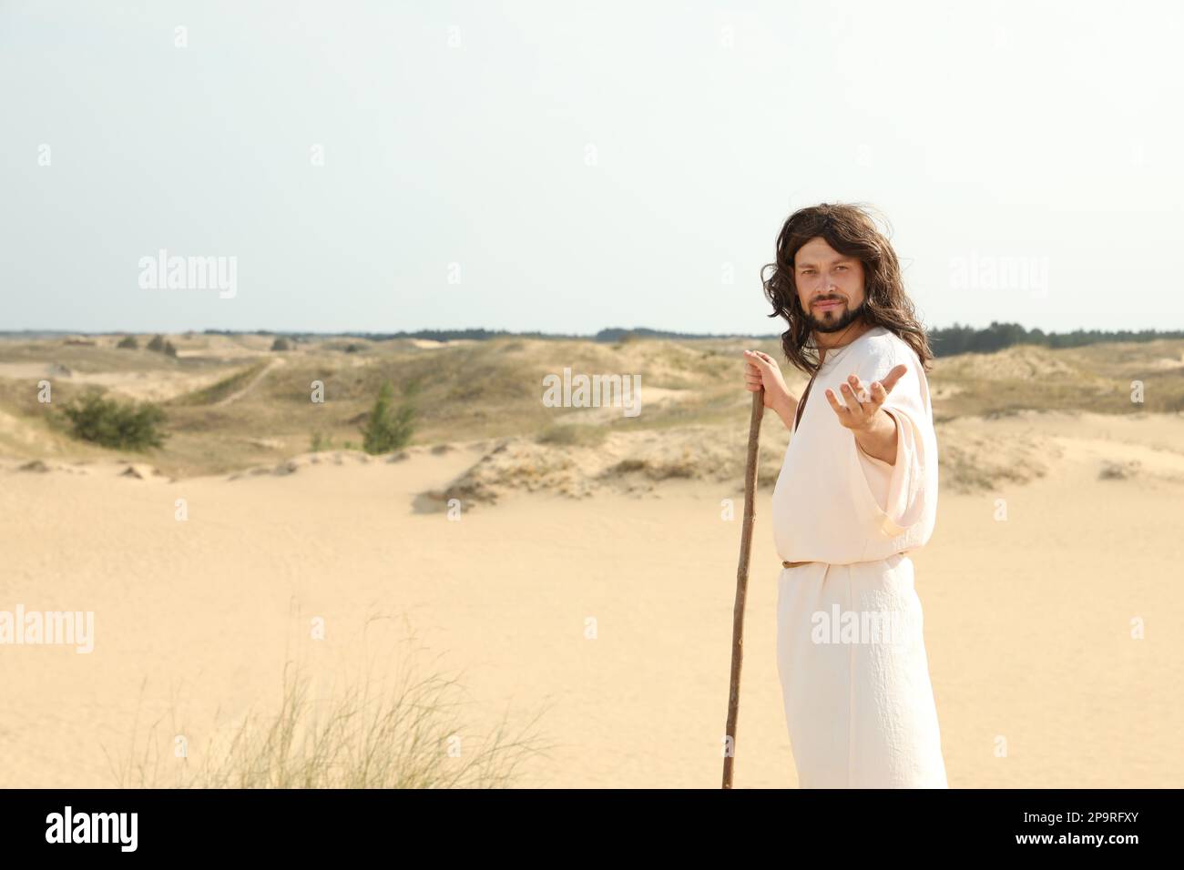 Jesus Christ walking with stick in desert. Space for text Stock Photo ...