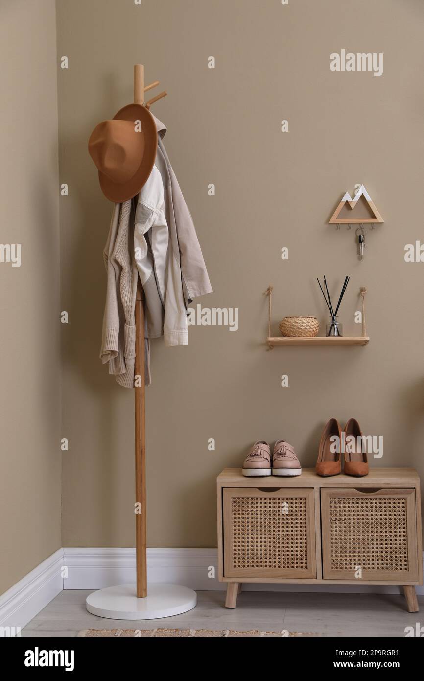 Modern hallway interior with stylish furniture and wooden hanger for ...