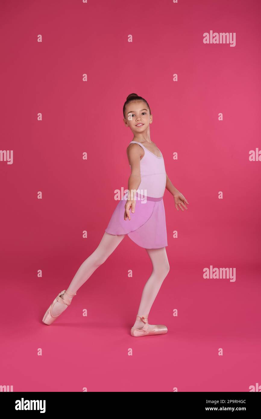Little ballerina practicing dance moves on pink background Stock Photo ...