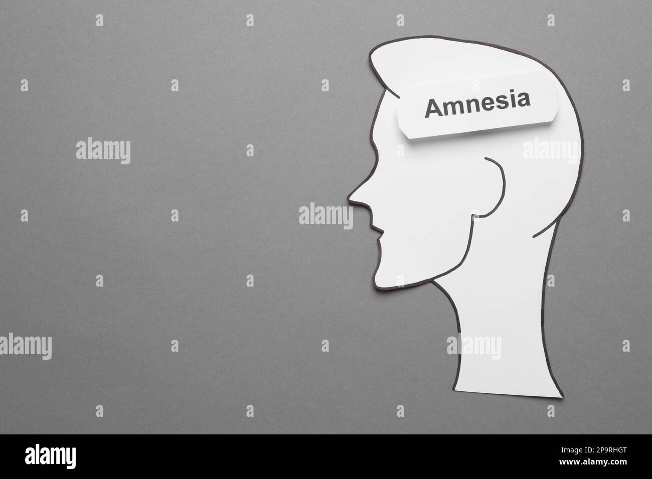 Card with word Amnesia and human head cutout on grey background, top ...