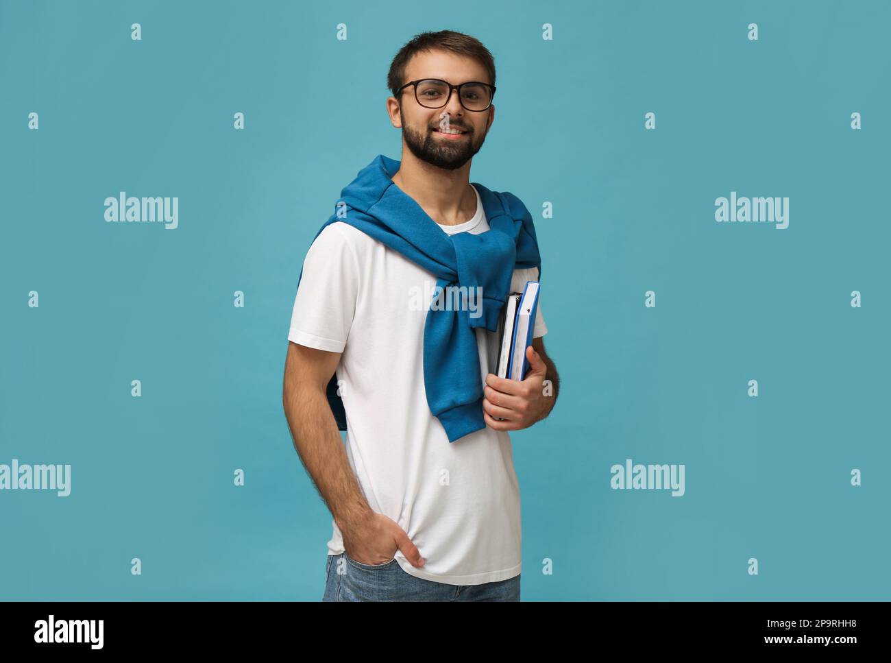 Student with books on light blue background Stock Photo - Alamy