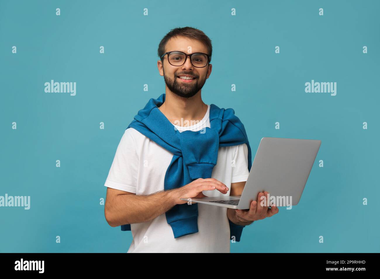 Student using laptop on light blue background Stock Photo - Alamy