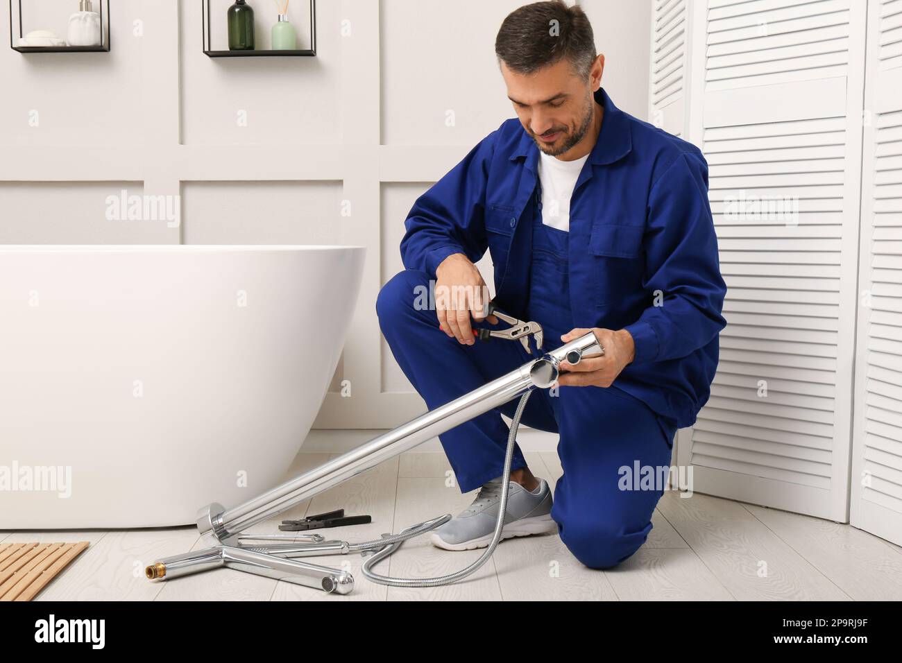Professional plumber installing water tap in bathroom Stock Photo - Alamy