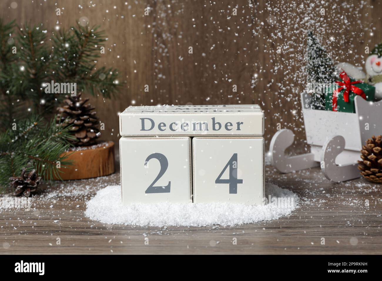 December 24 - Christmas Eve. Snow falling onto wooden block calendar ...