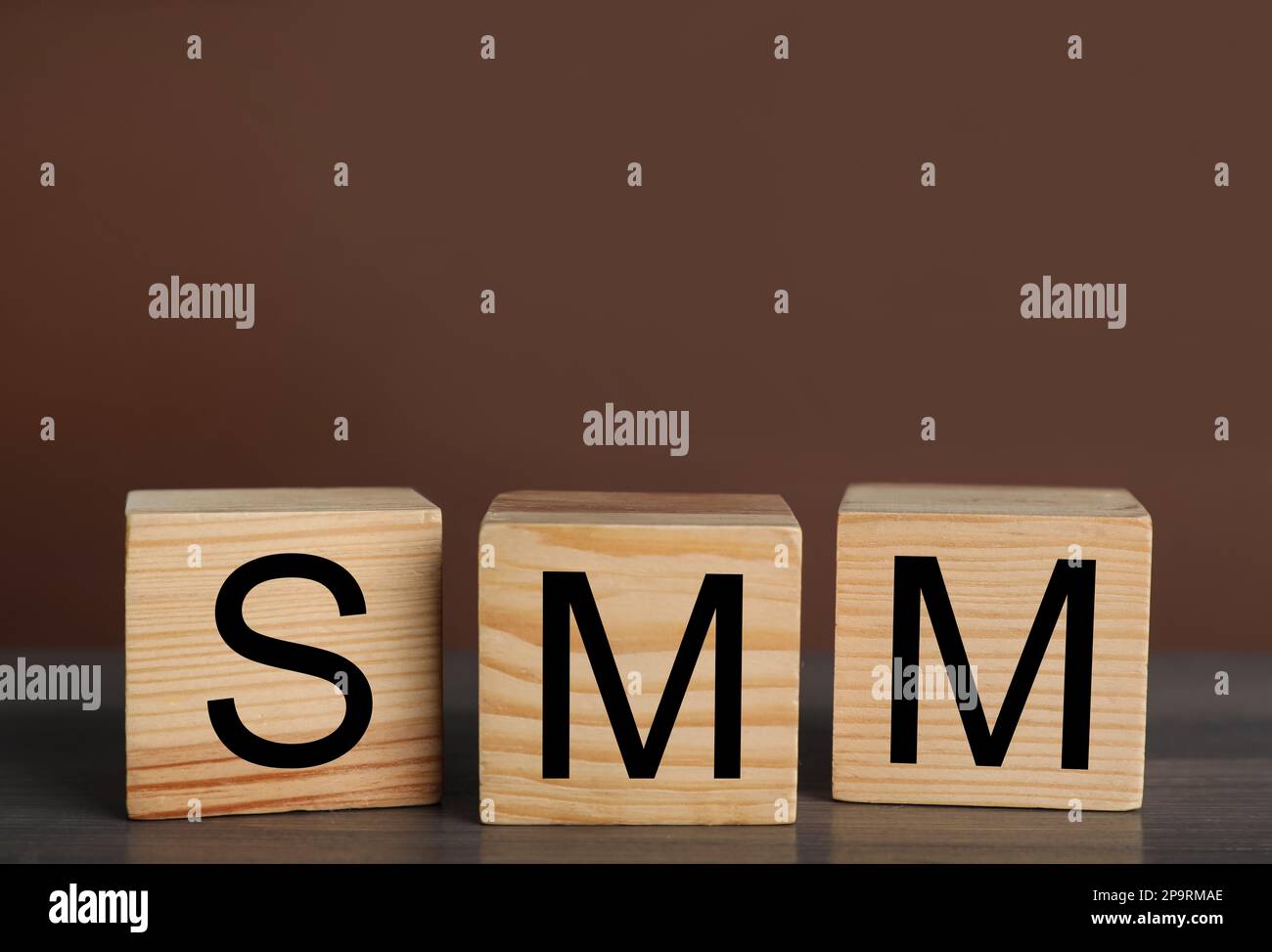 Cubes with abbreviation SMM (Social media marketing) on grey table ...