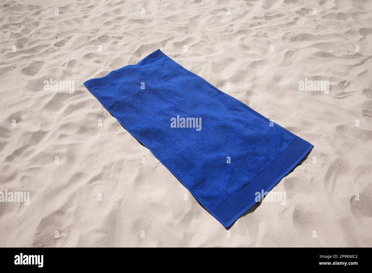 Beautiful soft blue beach towel on sand Stock Photo - Alamy