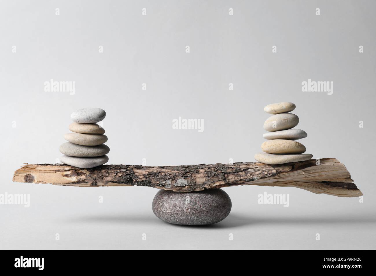 Tree branch with stones on grey background. Harmony and balance concept ...