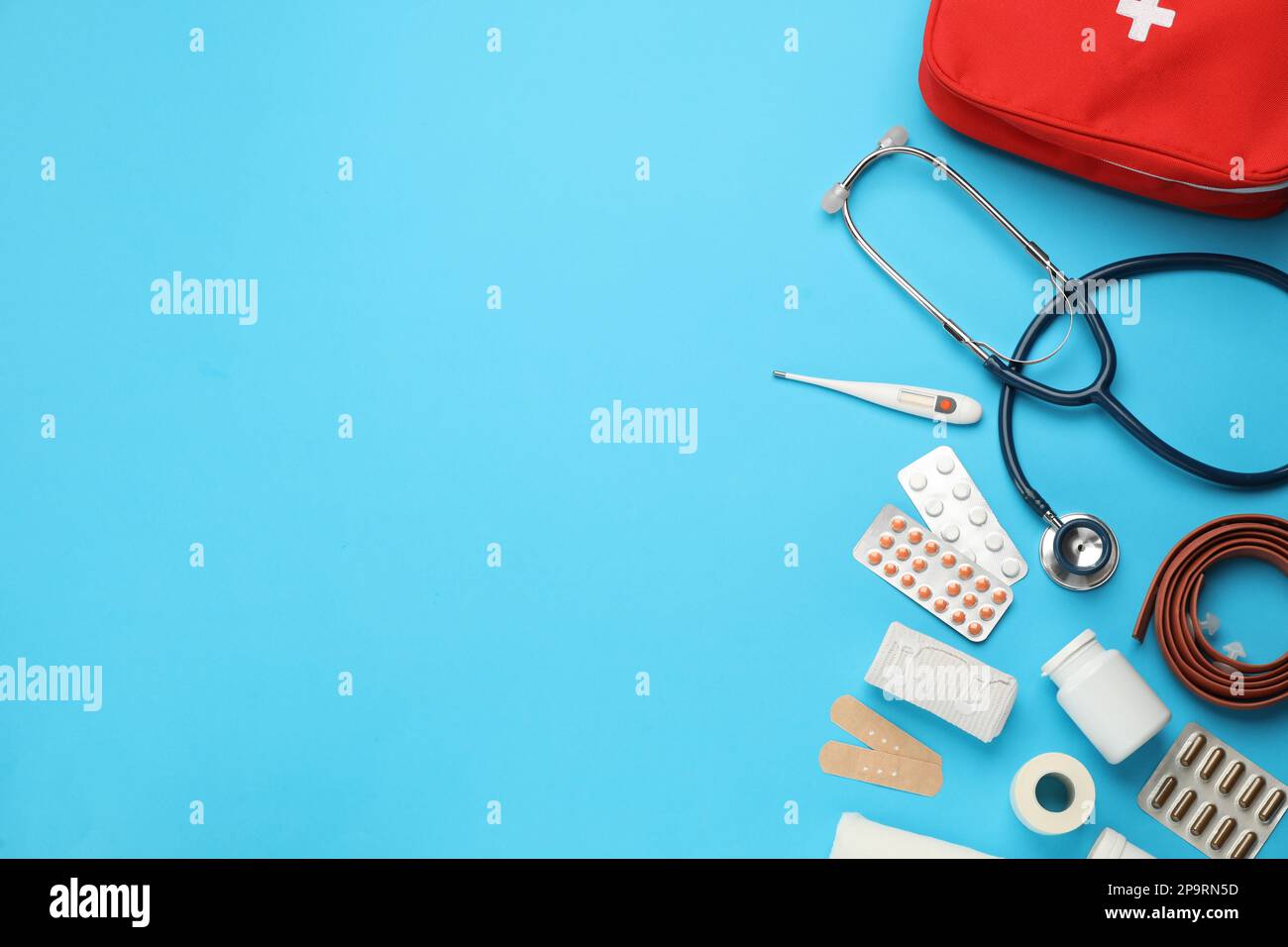 Flat lay composition with first aid kit on light blue background, space ...