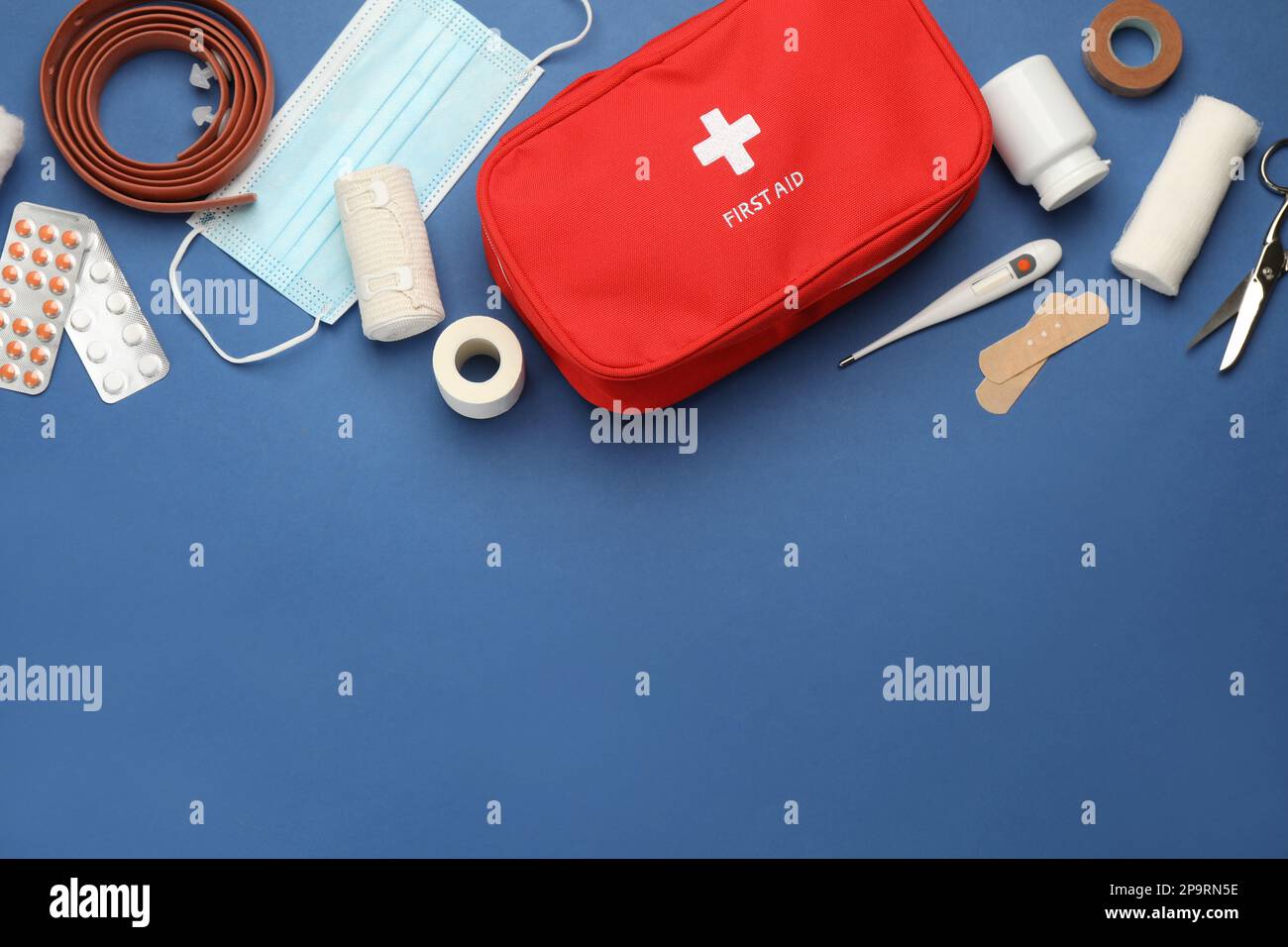 Flat lay composition with first aid kit on blue background, space for ...