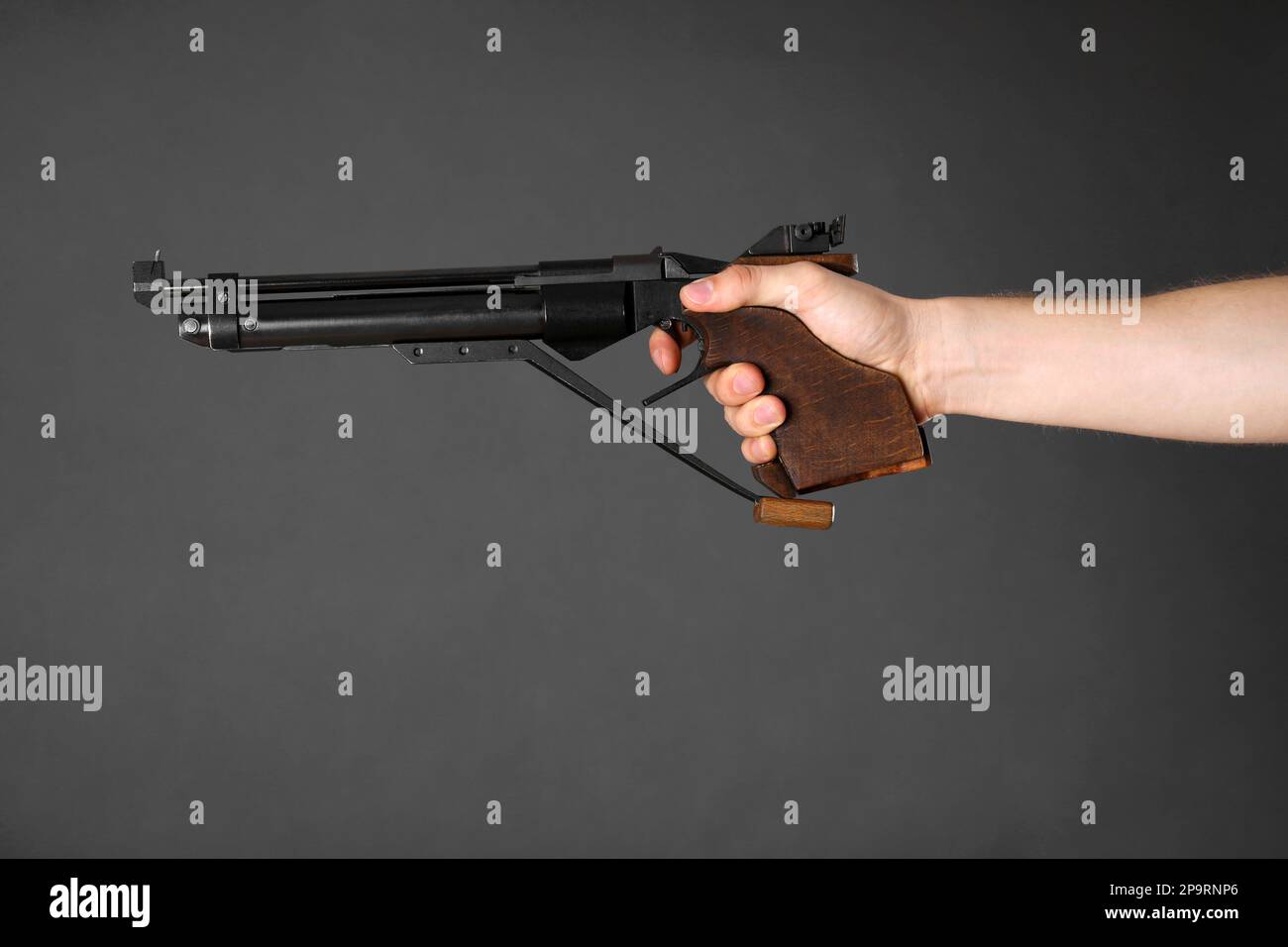 Gun shooting sport. Man aiming standard pistol on dark background ...